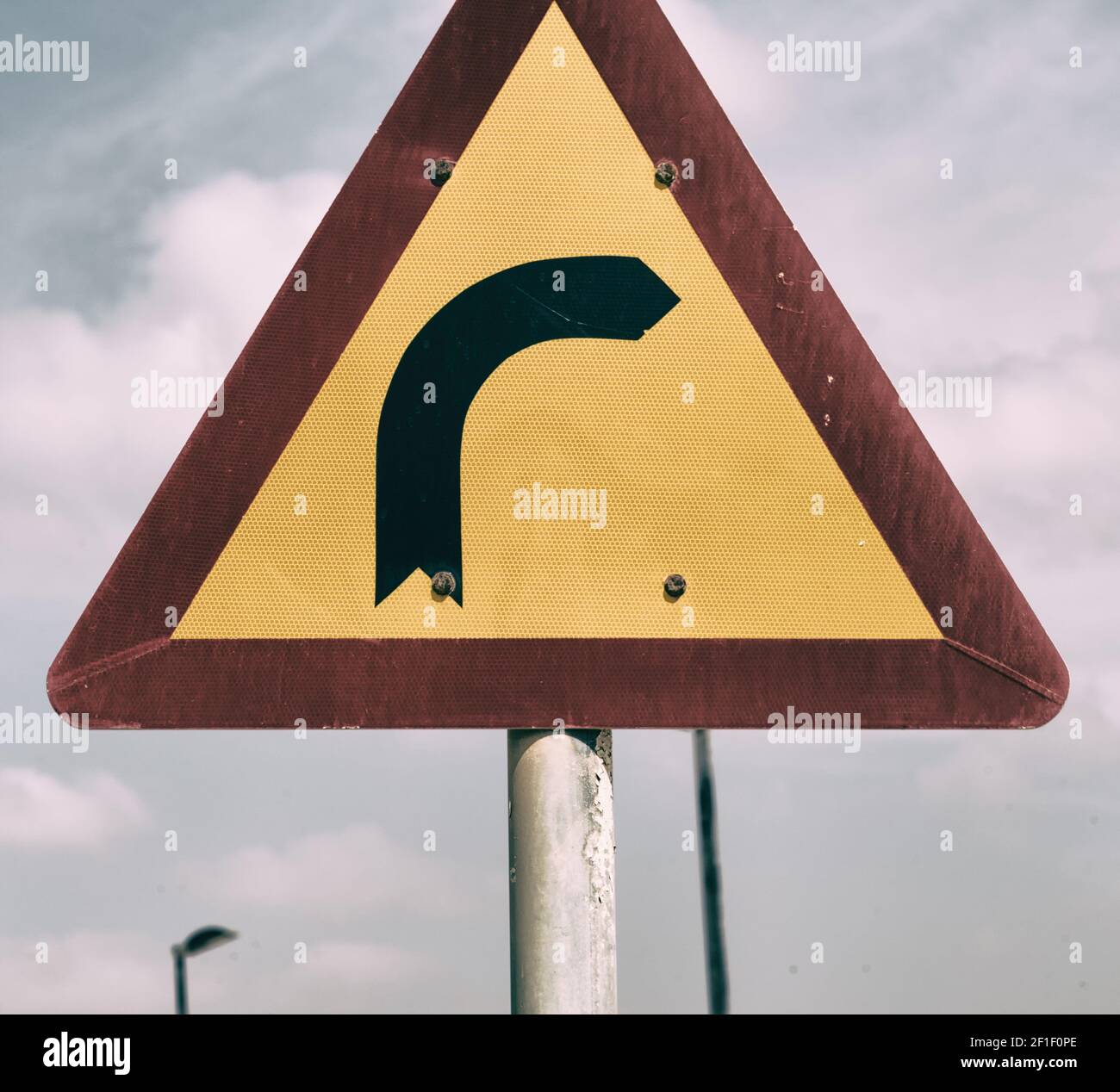 Road signal attention of the curve in the sky Stock Photo - Alamy