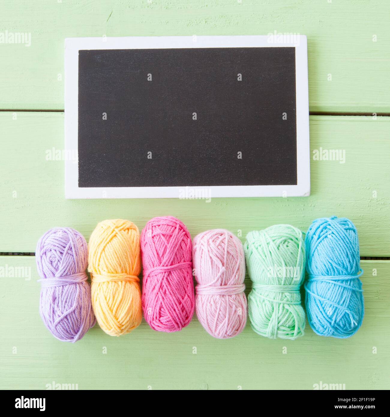 Colored yarns and chalkboard Stock Photo - Alamy