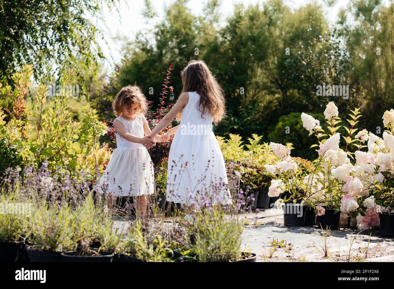 Little girls dancing among wonderful blooming flowers Stock Photo - Alamy