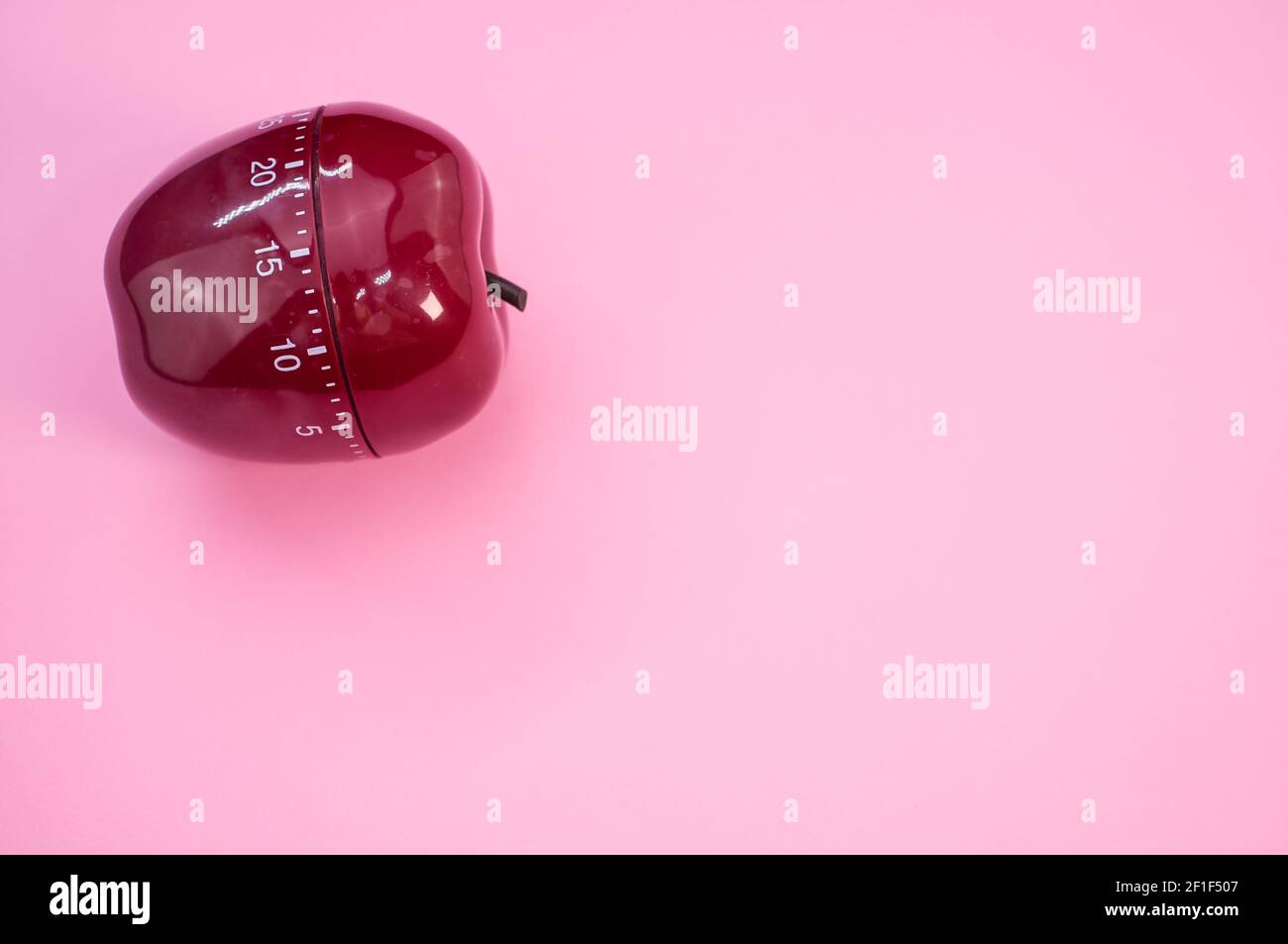 An apple-shaped kitchen timer isolated on pink background Stock Photo ...