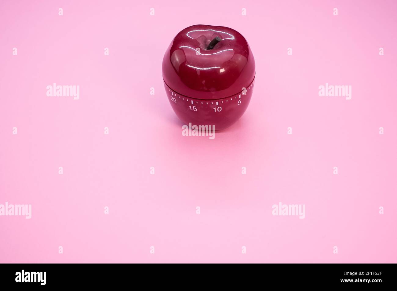 An apple-shaped kitchen timer isolated on pink background Stock Photo ...