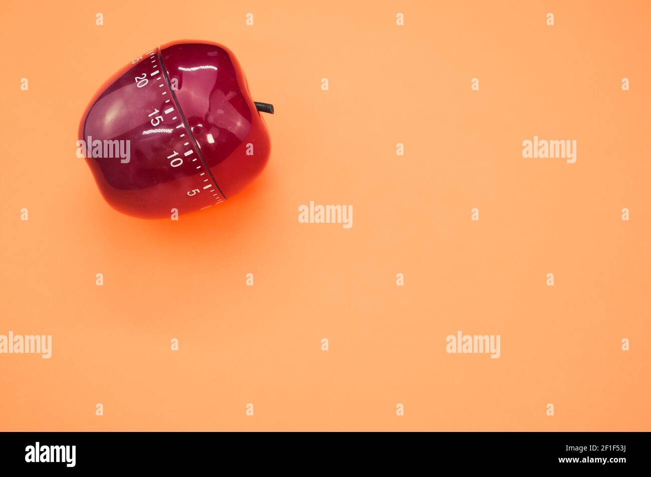 An apple-shaped kitchen timer isolated on orange background Stock Photo ...