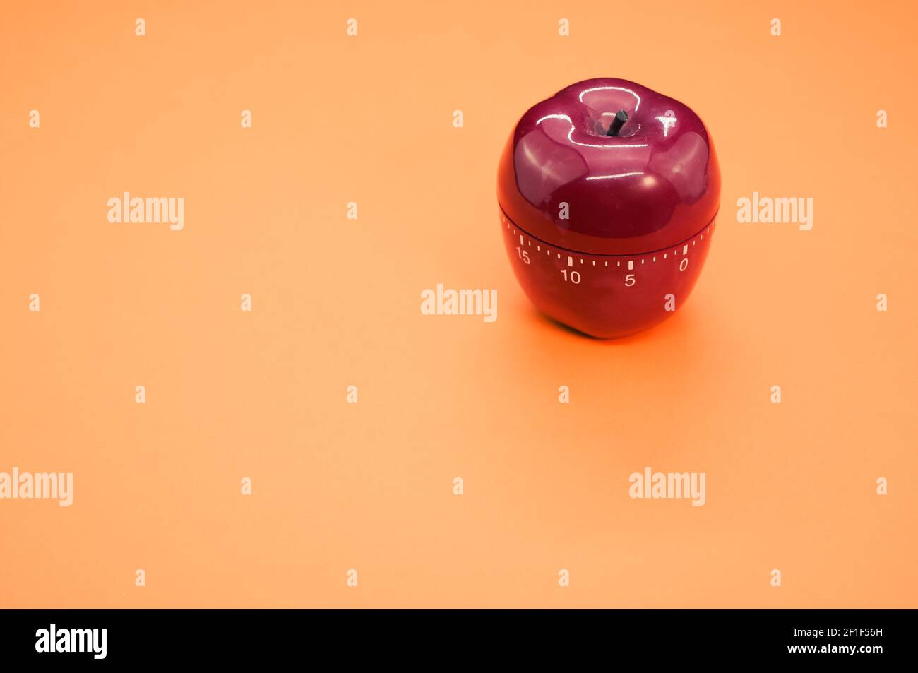 An apple-shaped kitchen timer isolated on orange background Stock Photo ...