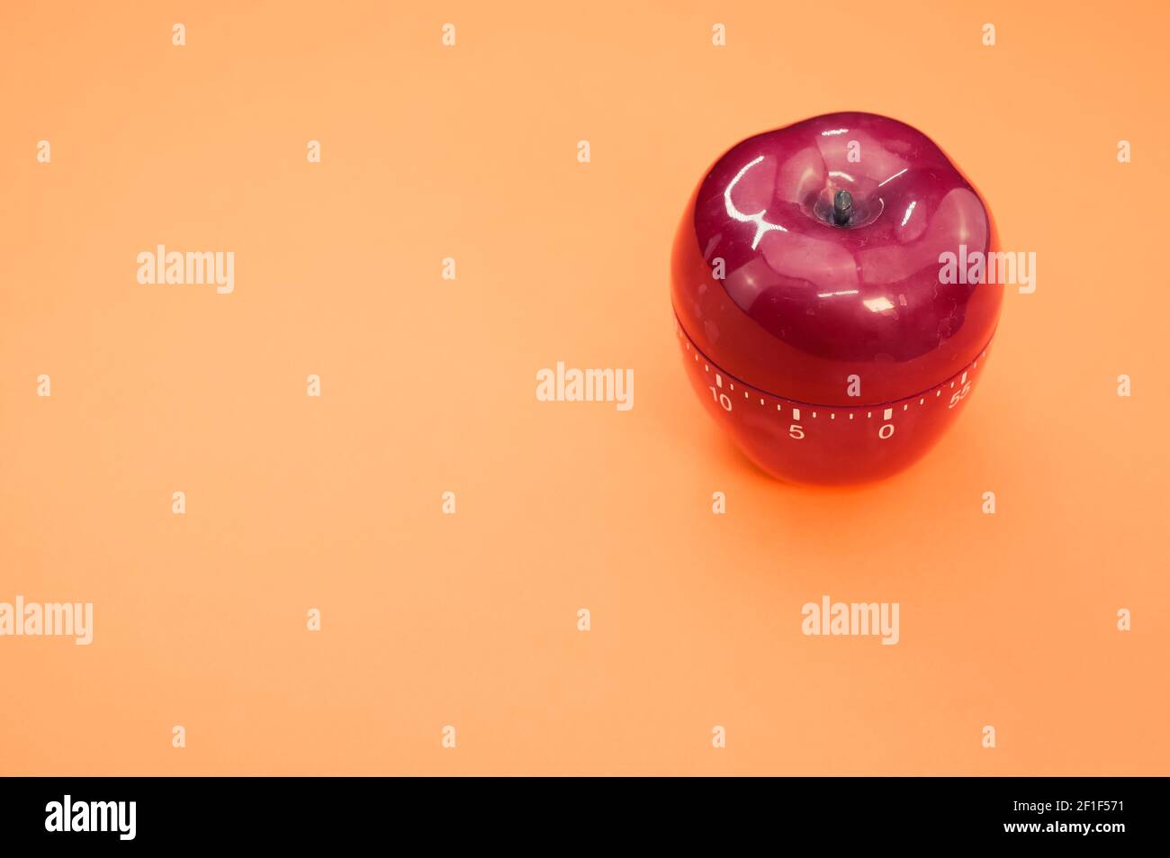 An apple-shaped kitchen timer isolated on orange background Stock Photo ...