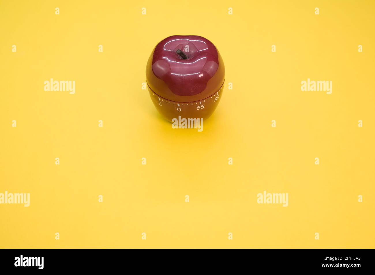 An apple-shaped kitchen timer isolated on yellow background Stock Photo ...