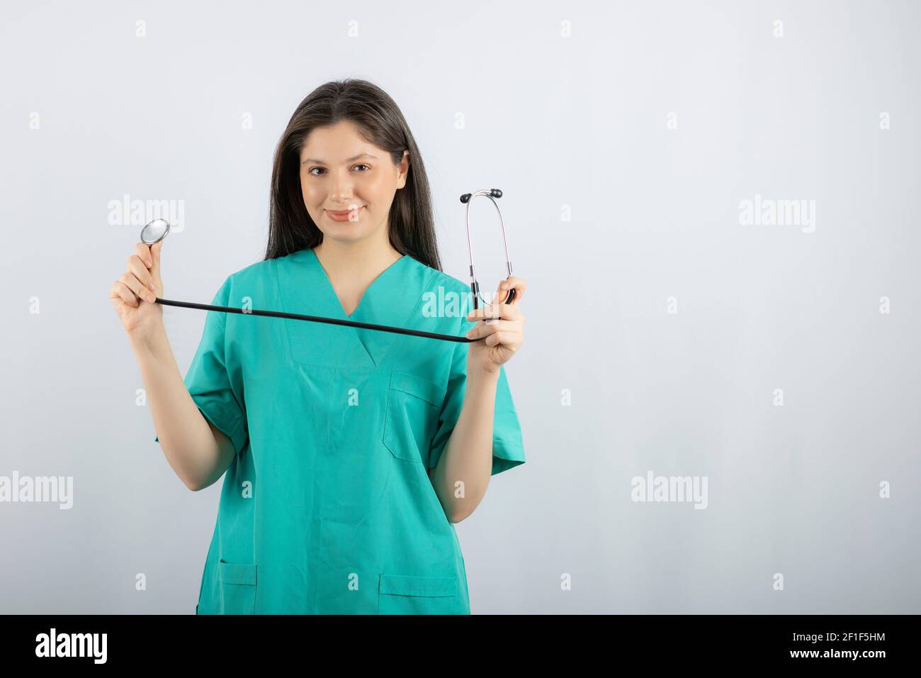 Portrait of female nurse with stethoscope posing on white background ...