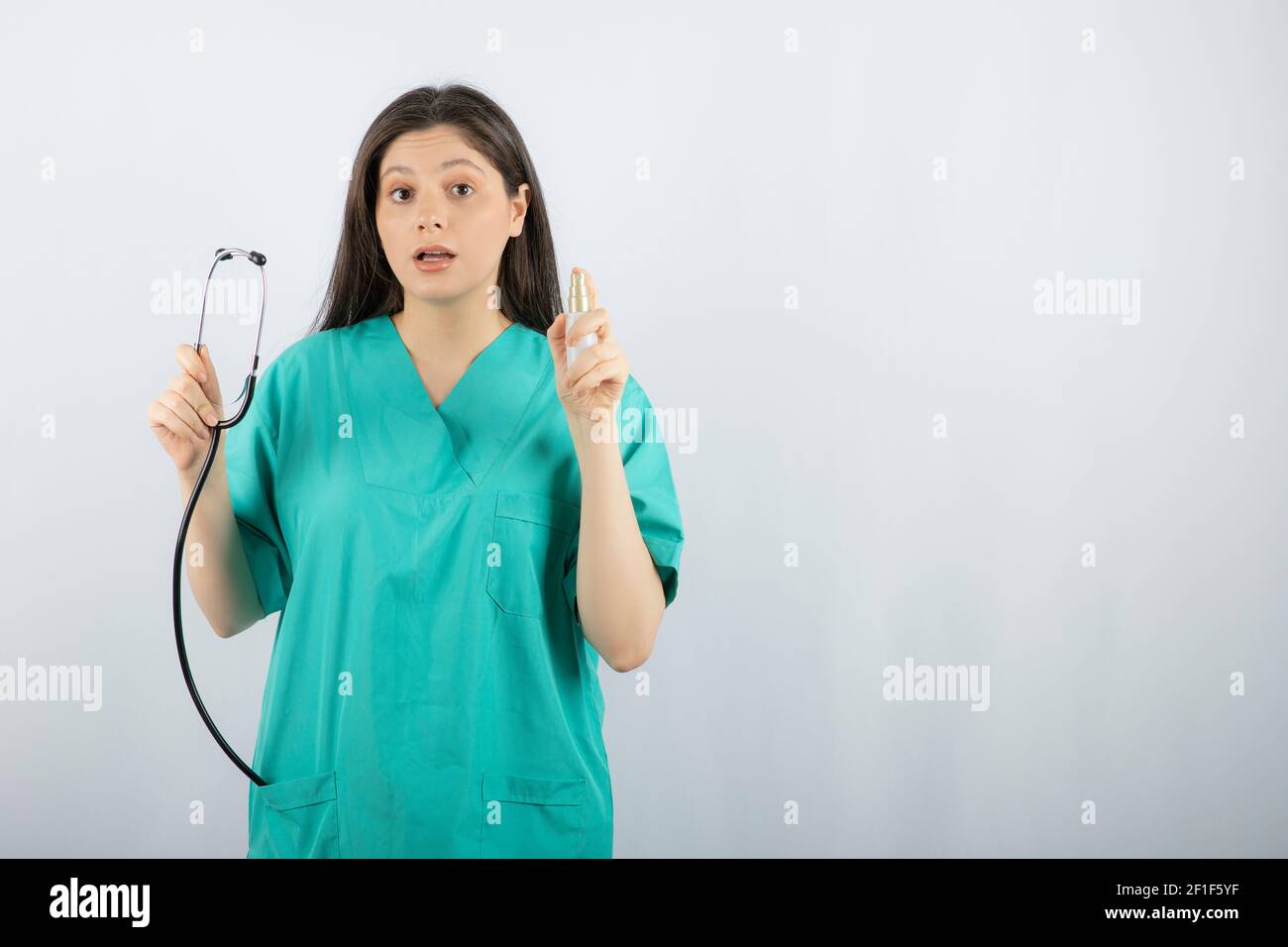 Portrait of female nurse holding stethoscope on white background Stock ...