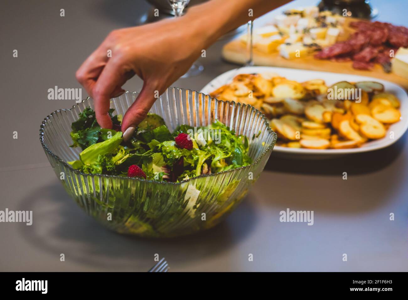 Set up table with salad and boards of appetizers Stock Photo - Alamy
