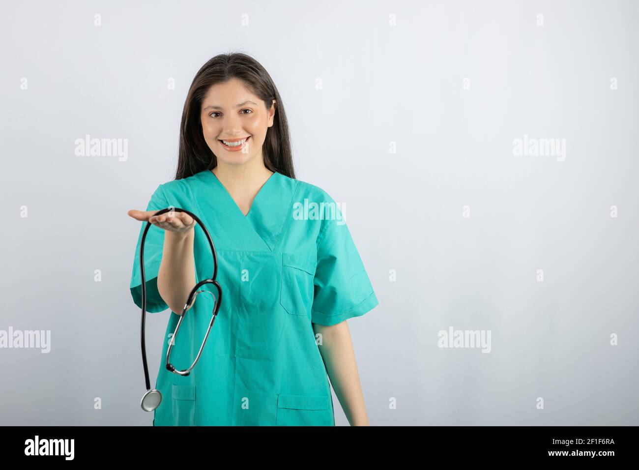 Portrait of female nurse showing stethoscope on white background Stock ...
