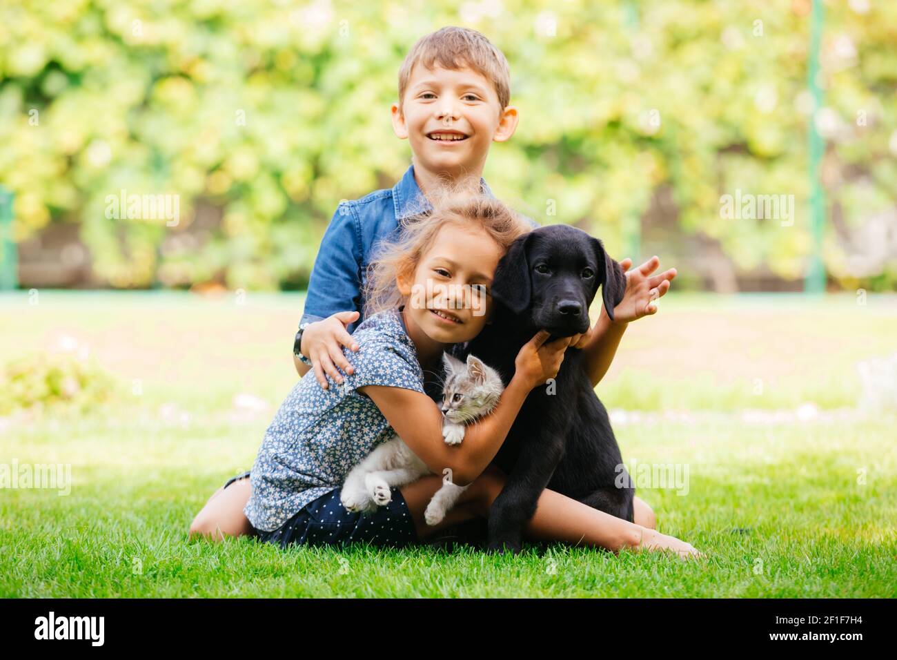 Close relationship between siblings and their pets Stock Photo - Alamy