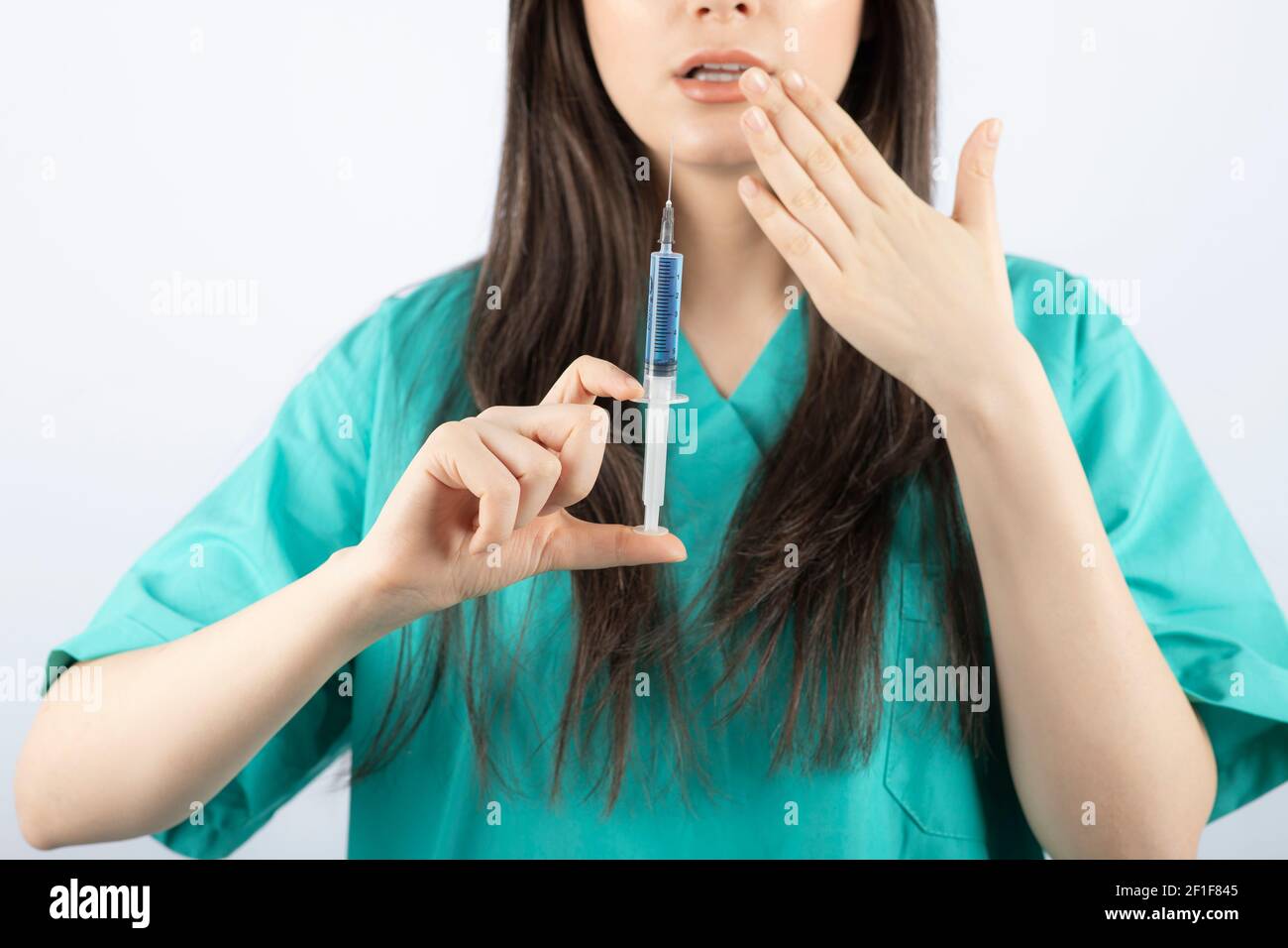 Portrait of female doctor holding a large syringe Stock Photo - Alamy