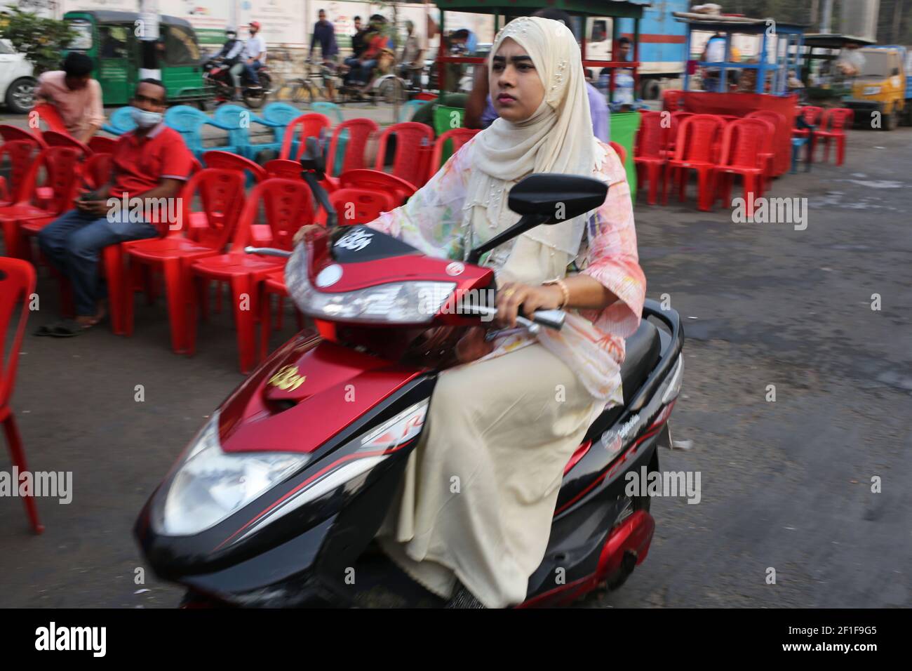 Dhaka, Bangladesh. March 8, 2021: A muslim woman is riding a scooty in ...