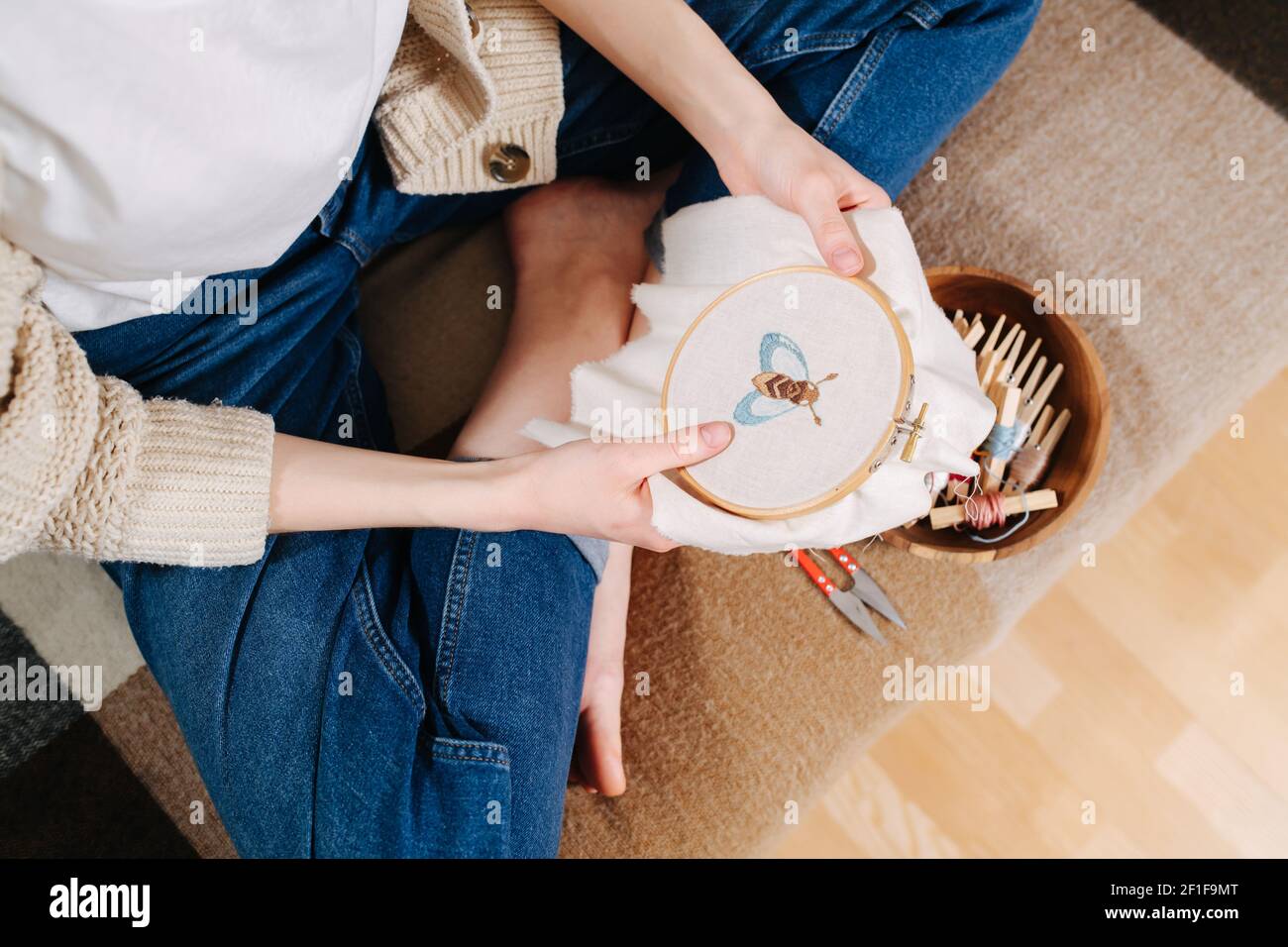Top view of a young woman holding loop with embroidered picture of a ...