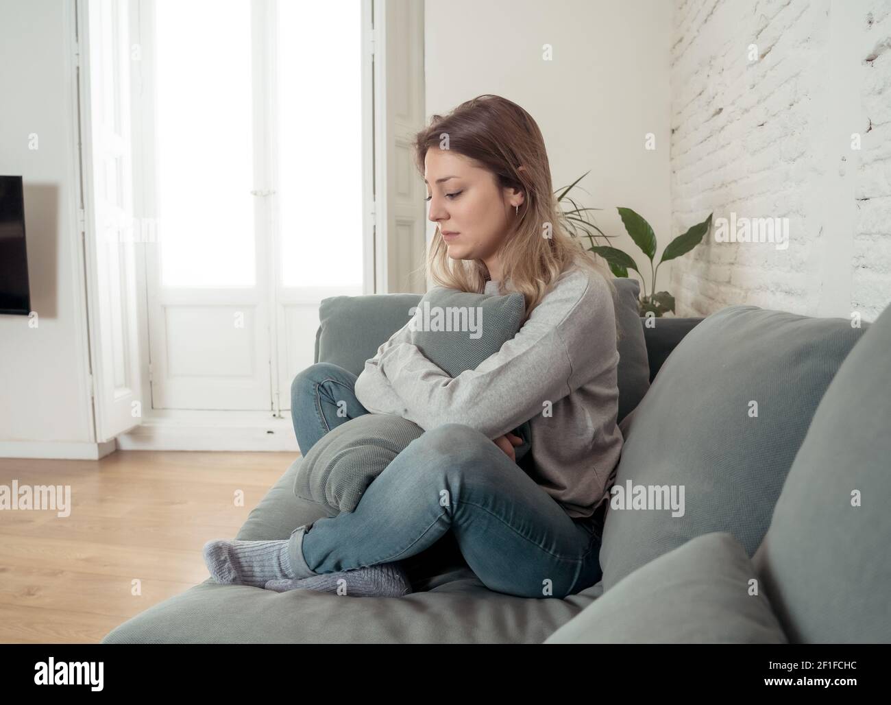 Depressed sad attractive woman crying on sofa couch at home feeling ...