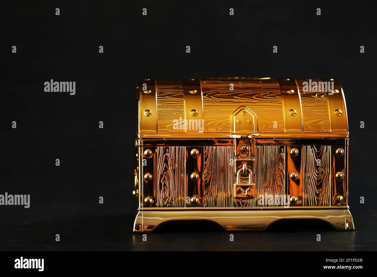 A chest made of gold with jewels on a black background. Free space, the ...