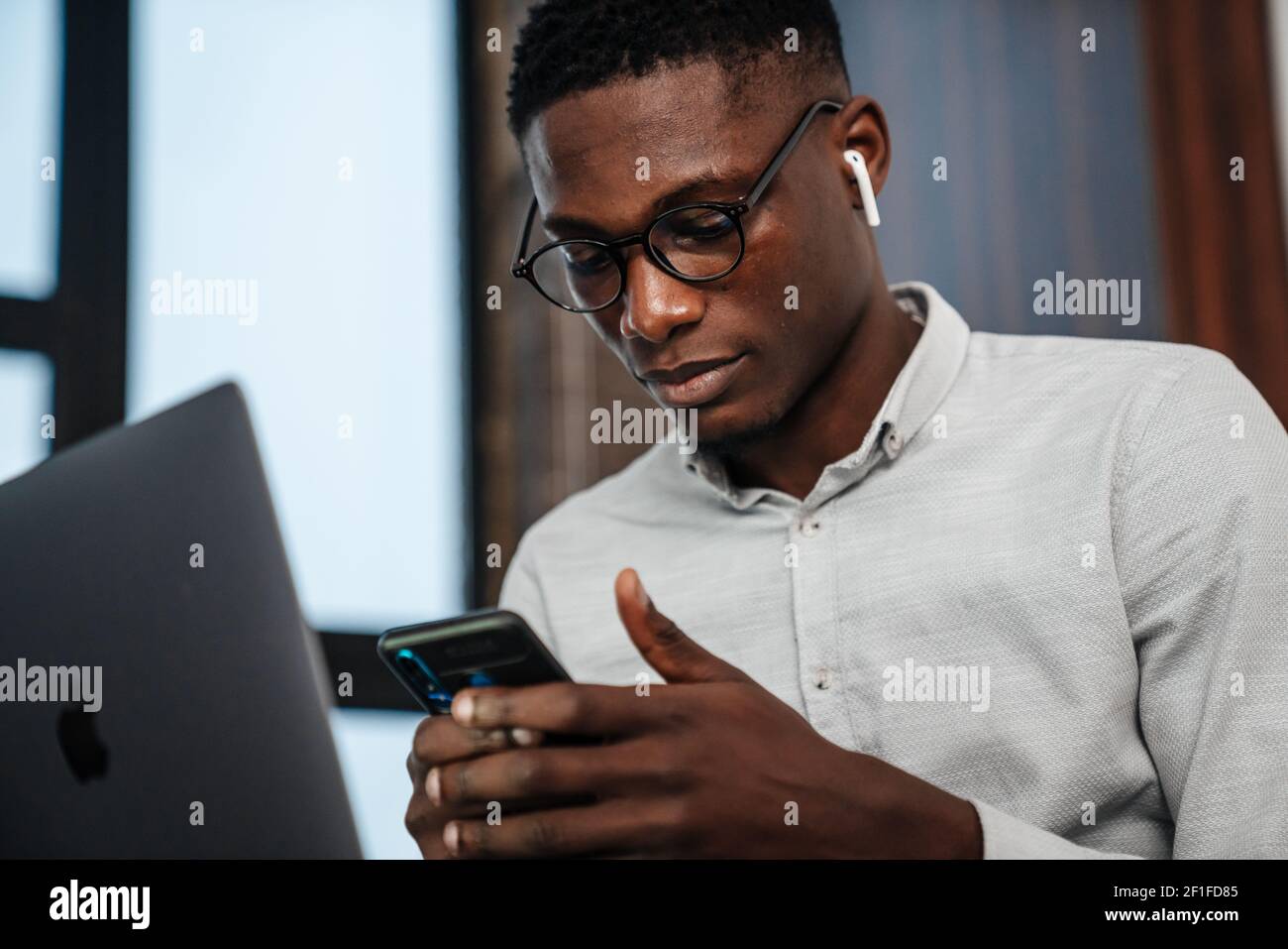 Attractive young dark-skinned businessman wearing formal clothing and ...