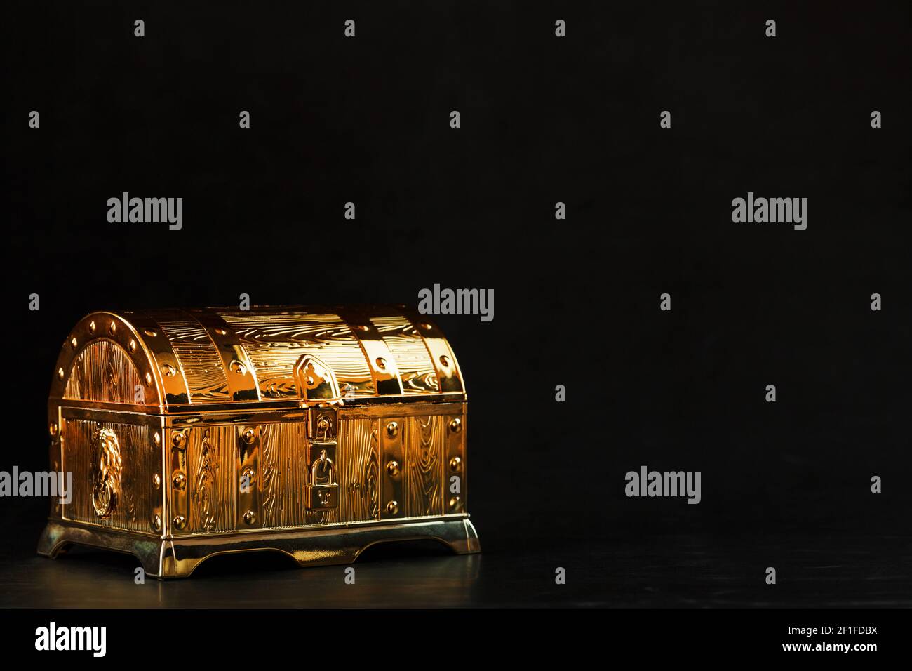A chest made of gold with jewels on a black background. Free space, the ...