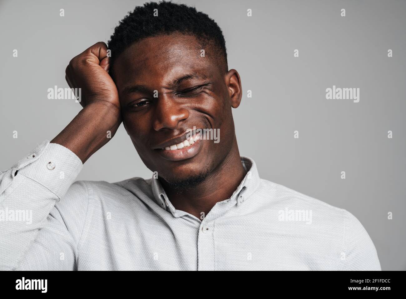 Upset african man in white shirt suffering from a headache isolated ...