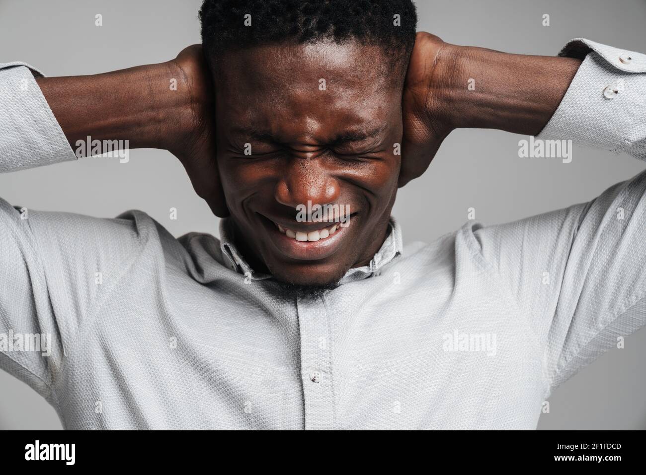 Upset african man in white shirt suffering from a headache isolated ...