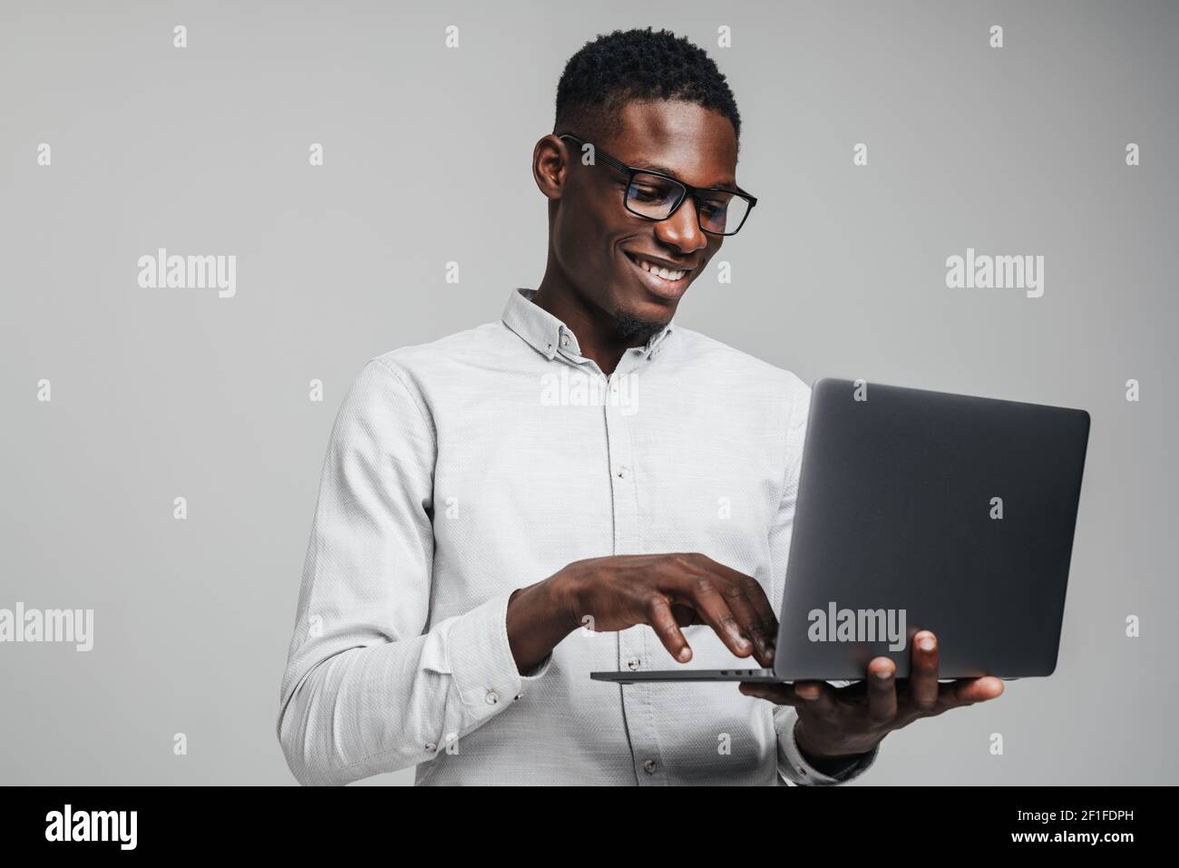 Handsome smiling young african business man using laptop computer ...