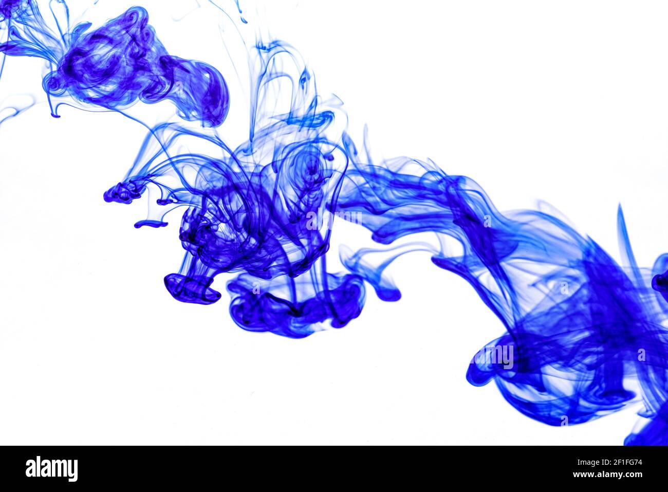 Blue ink injected into water from syringe, colour mixing with water ...