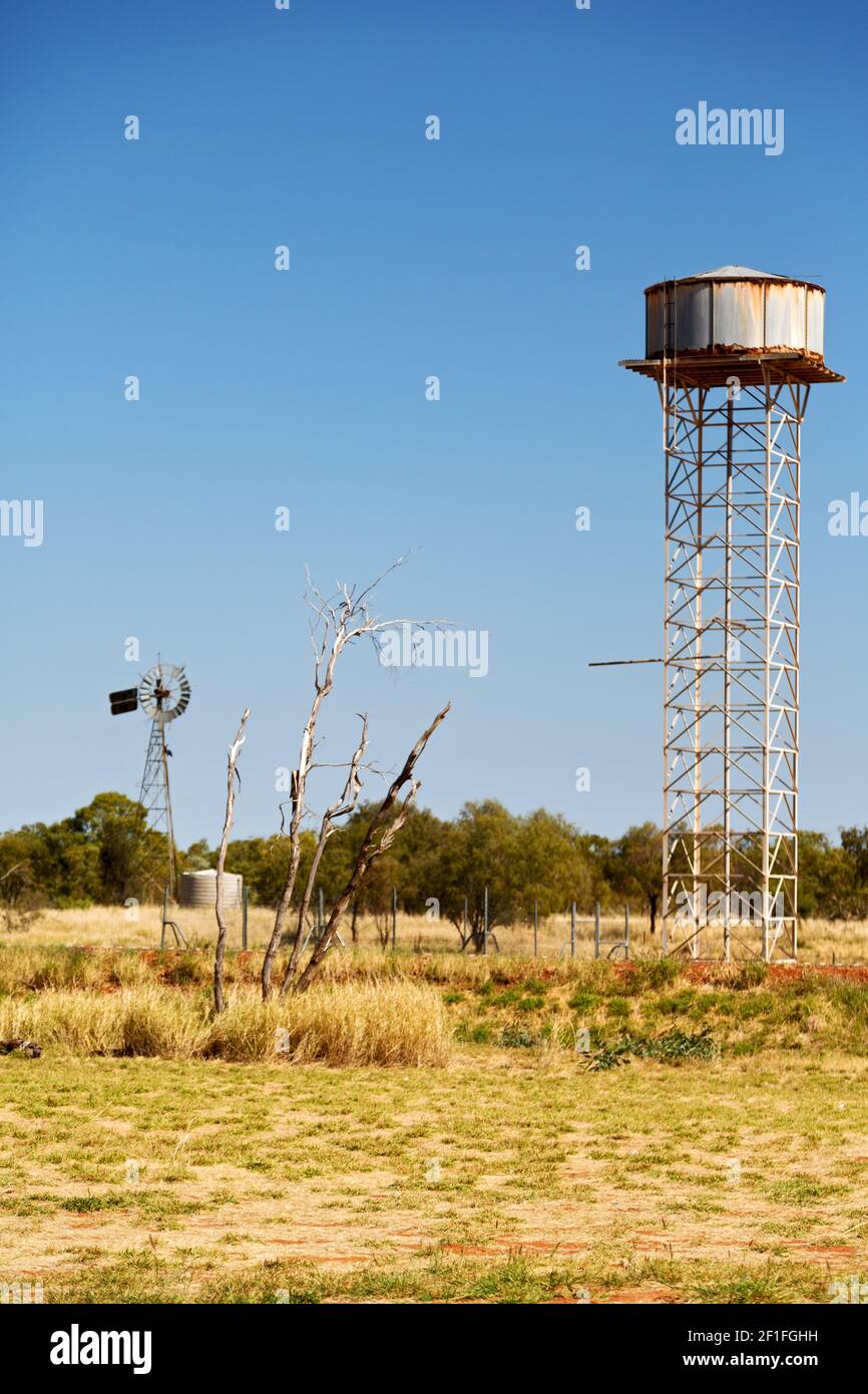In the outback with asphalt line and water tank Stock Photo - Alamy