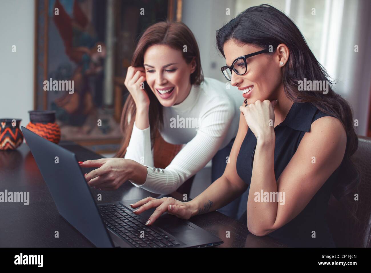 Happy young co-wokers joking at laptop, Caucasian women, online ...