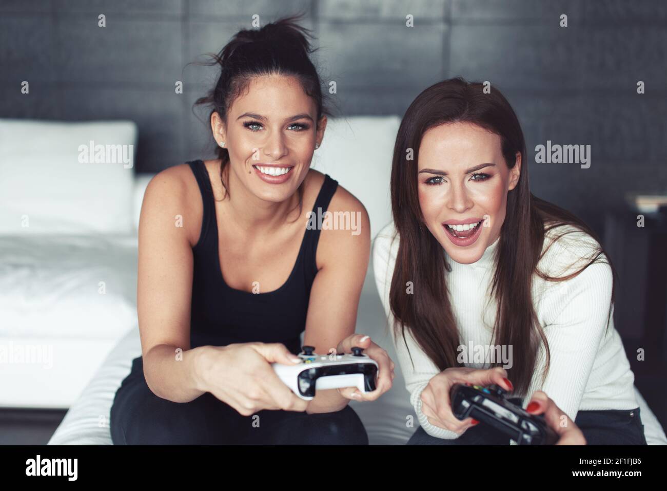 Happy young Caucasian women playing on console at home Stock Photo - Alamy