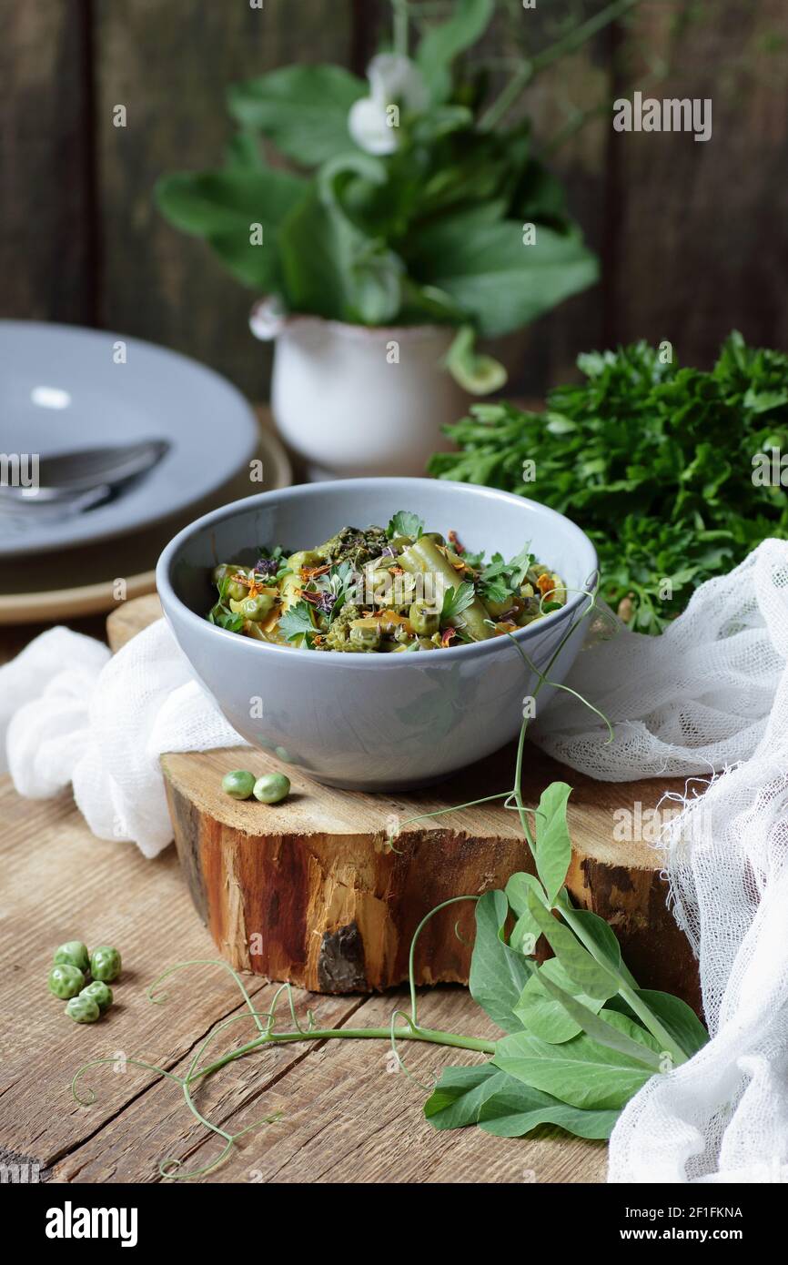 Vegan protein meal, dish of stewed green legume vegetables: peas, green ...