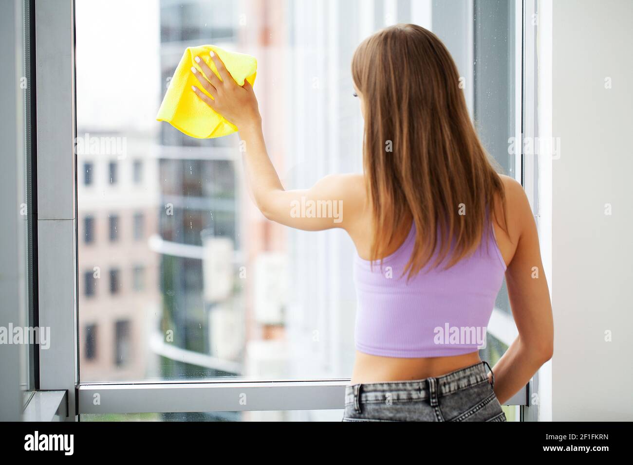 Young smiling woman washing windows with a sponge Stock Photo - Alamy