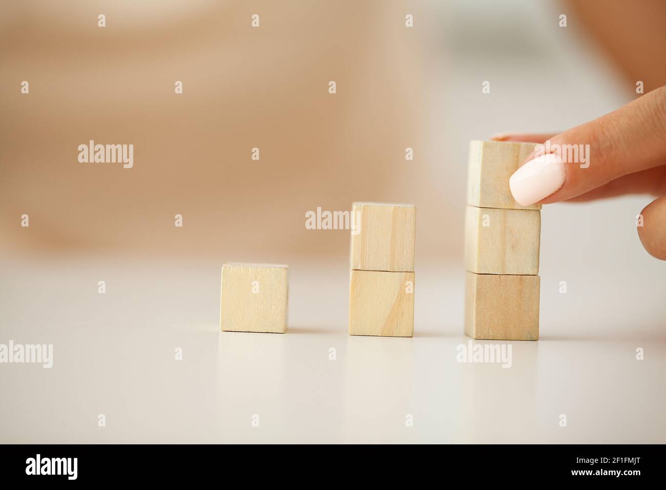 Woman hand putting and stacking blank wooden cubes on desk with copy ...