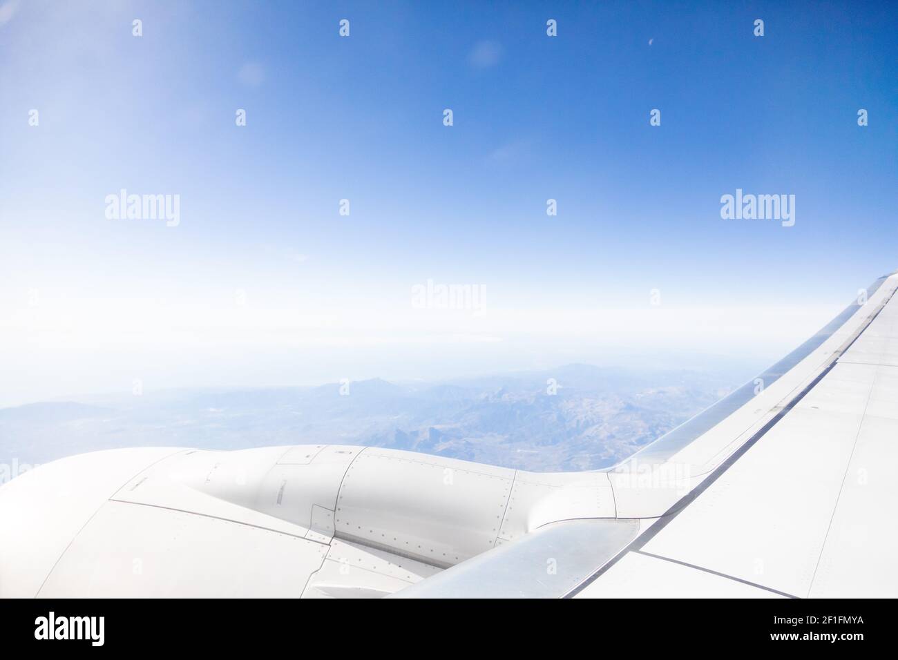 airplane wing out the window, flying, bright blue sky Stock Photo - Alamy