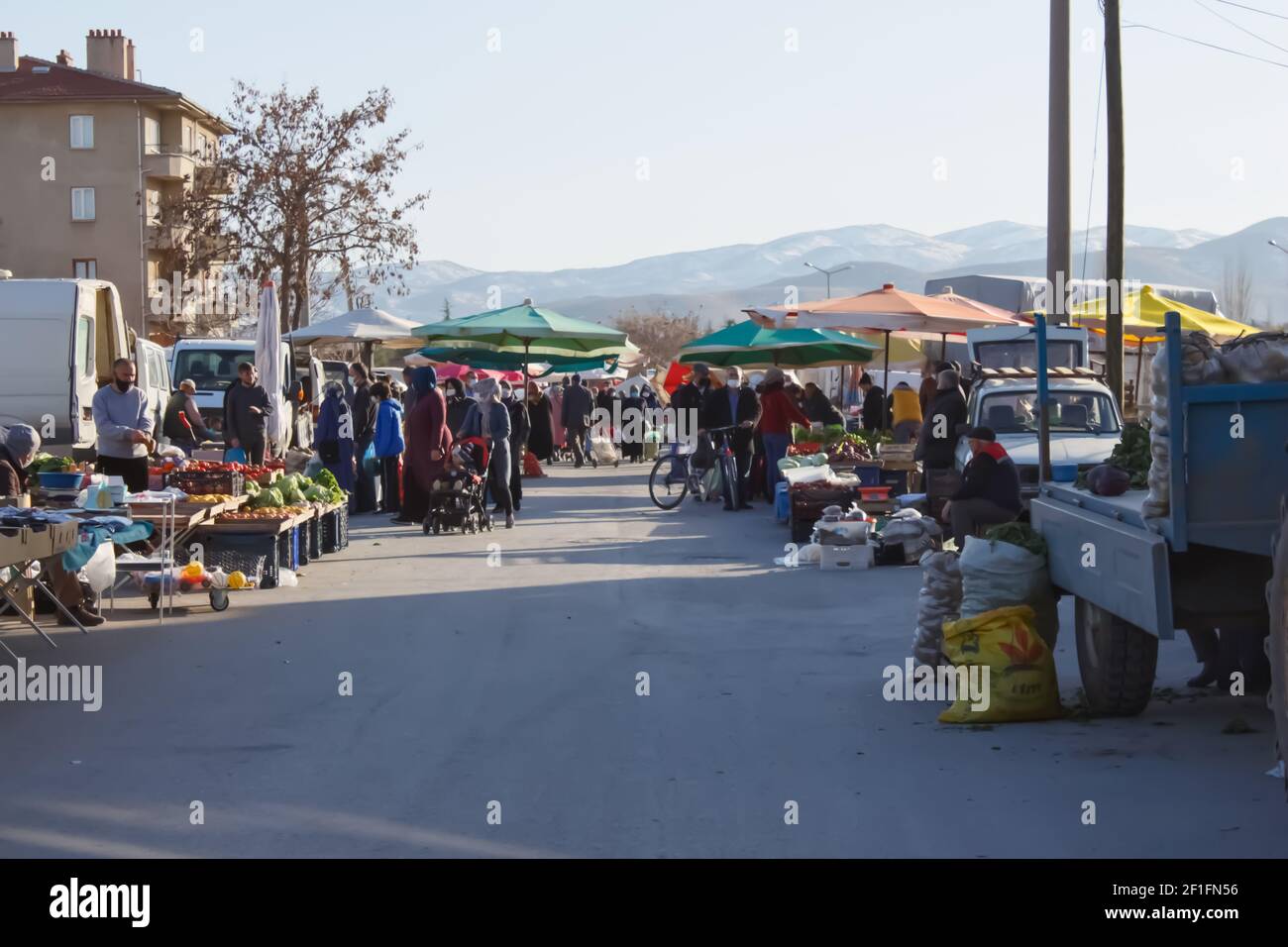 People shop at the local market. The crowd wears a medical mask due to ...