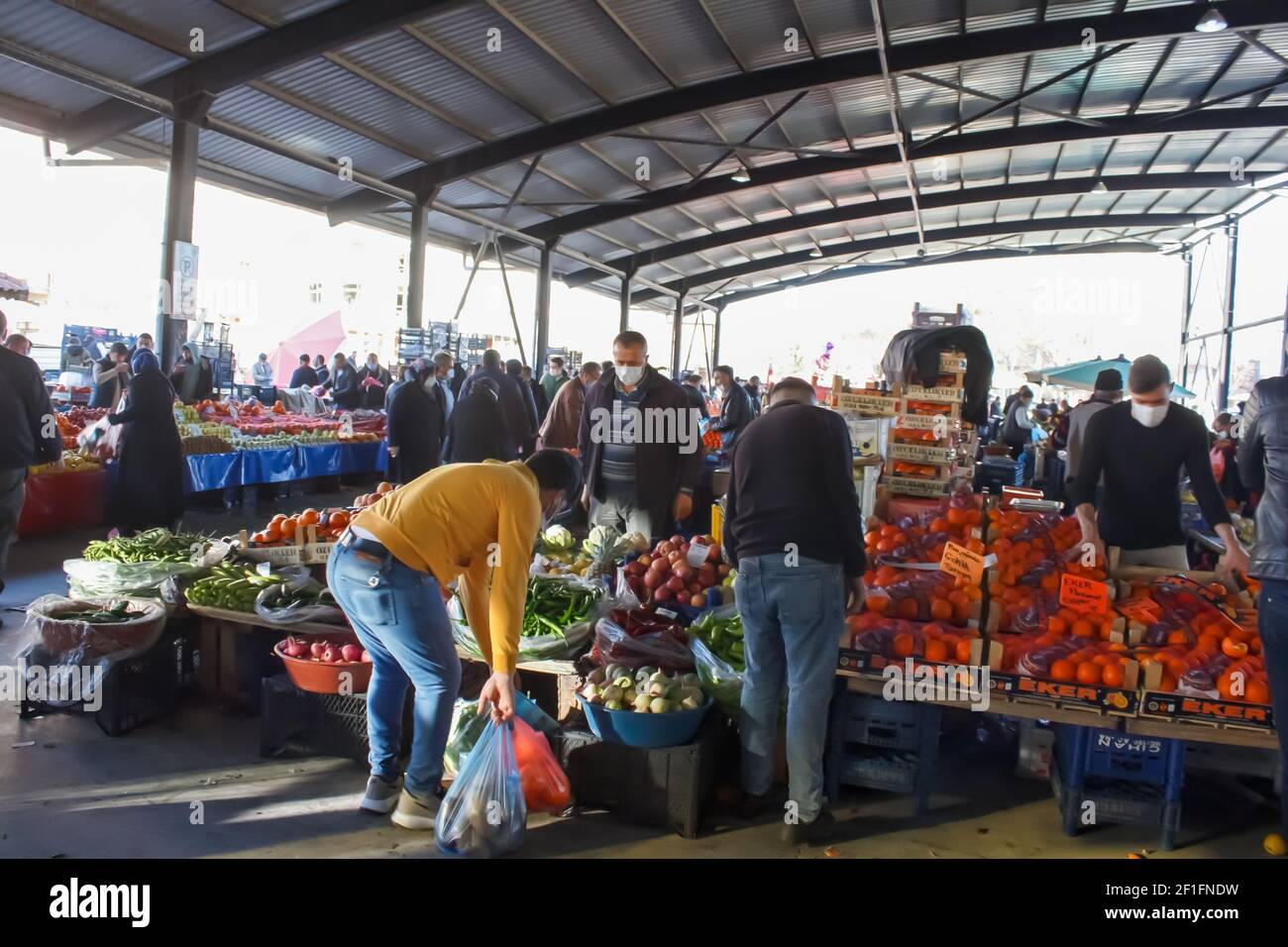 People shop at the local market. The crowd wears a medical mask due to ...