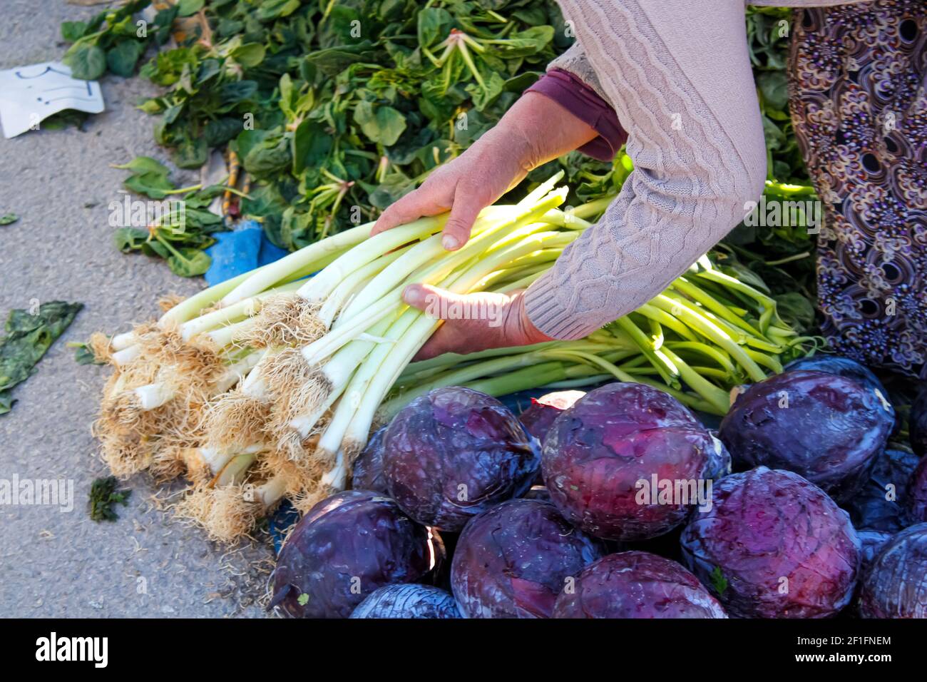 The marketplace old woman takes leeks to give to the customer. Leeks ...