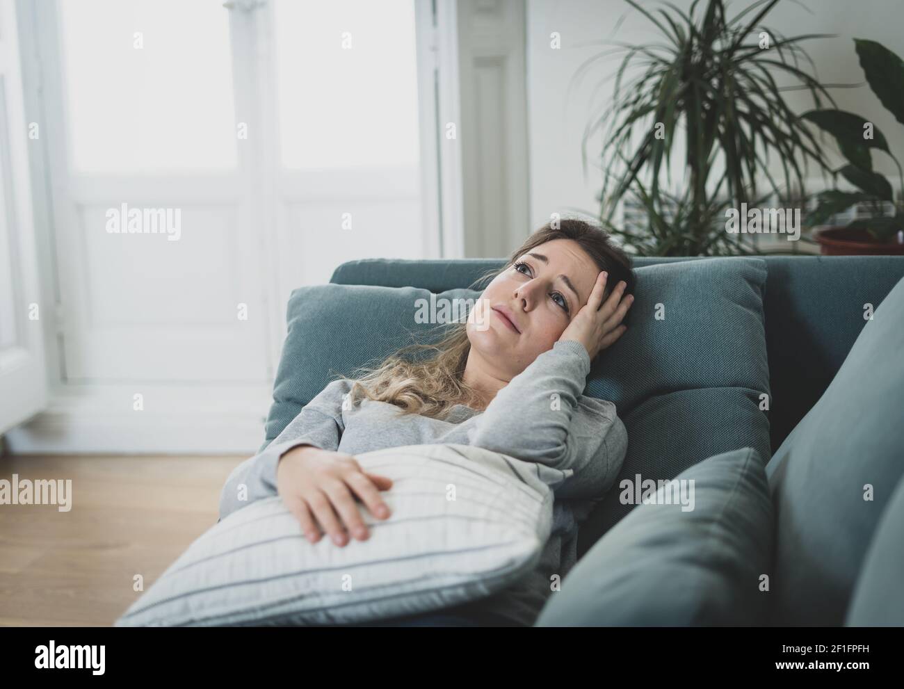 Depressed sad attractive woman crying on sofa couch at home feeling ...