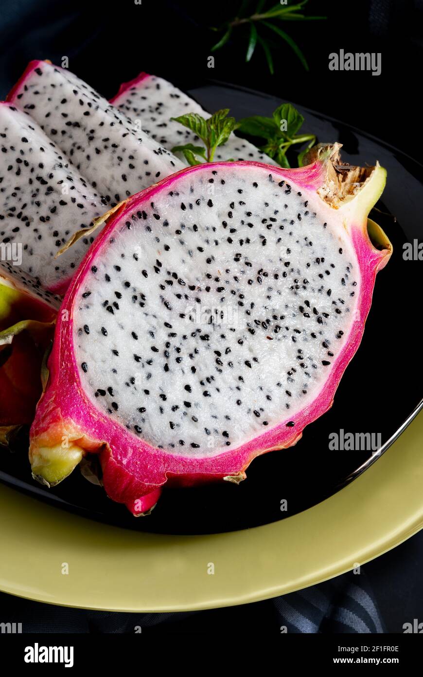 Red pitaya tropical fruit sliced with coconut diced on wooden table ...