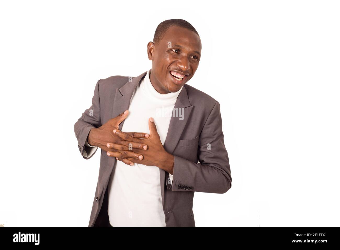 young man standing in suit on white background looking in profile ...
