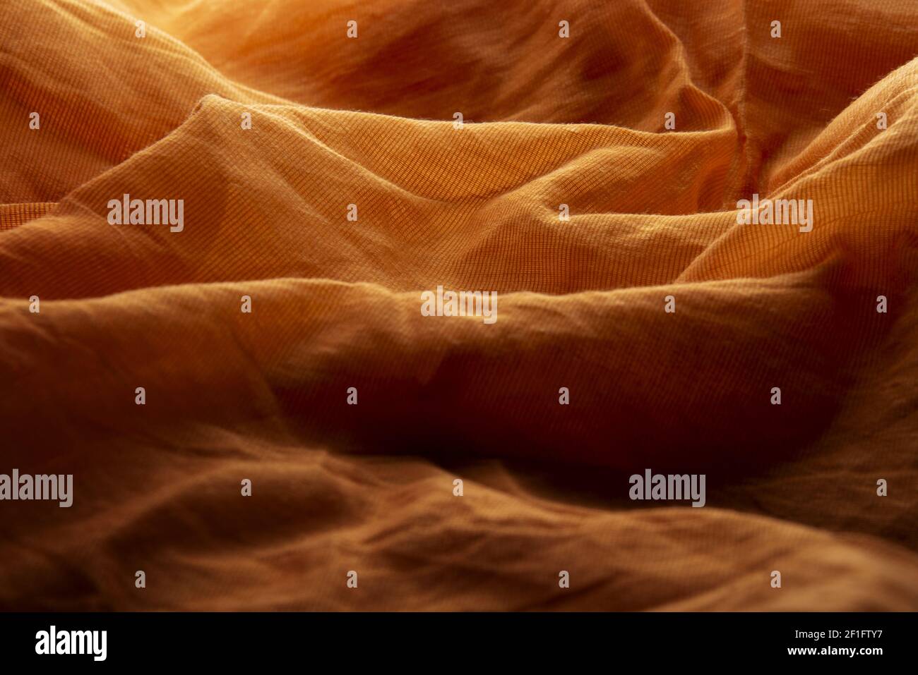 A wrinkled and grooved orange cloth texture background Stock Photo - Alamy