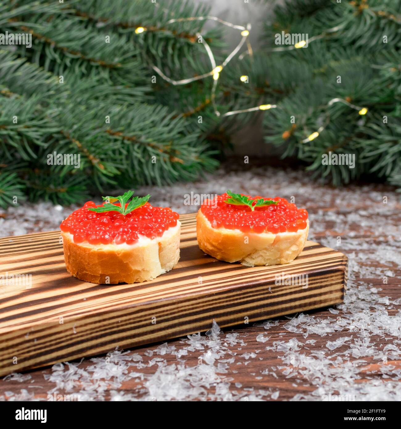 Sandwiches with red caviar on the background of the New Year tree on a ...