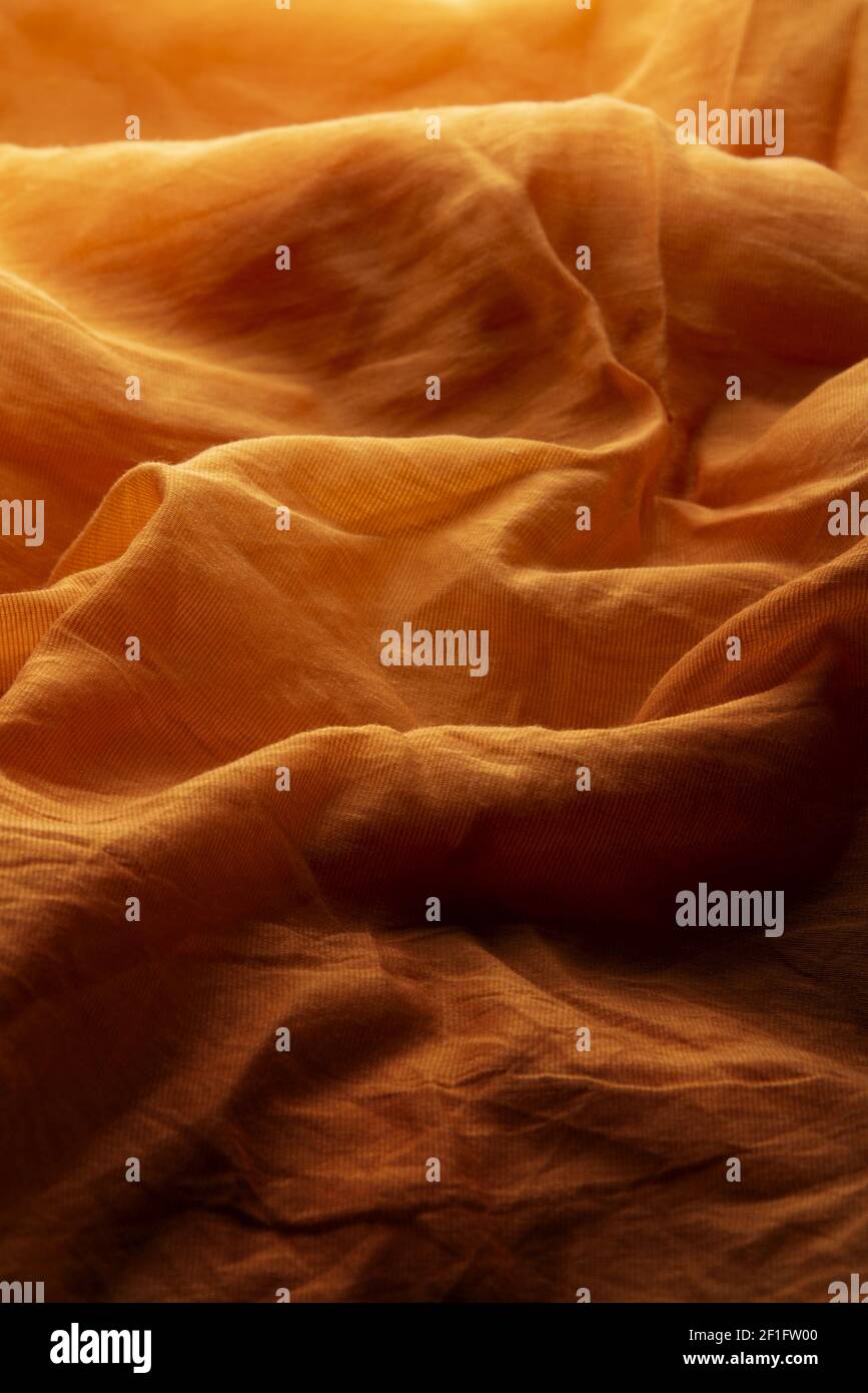 A wrinkled and grooved orange cloth texture background Stock Photo - Alamy