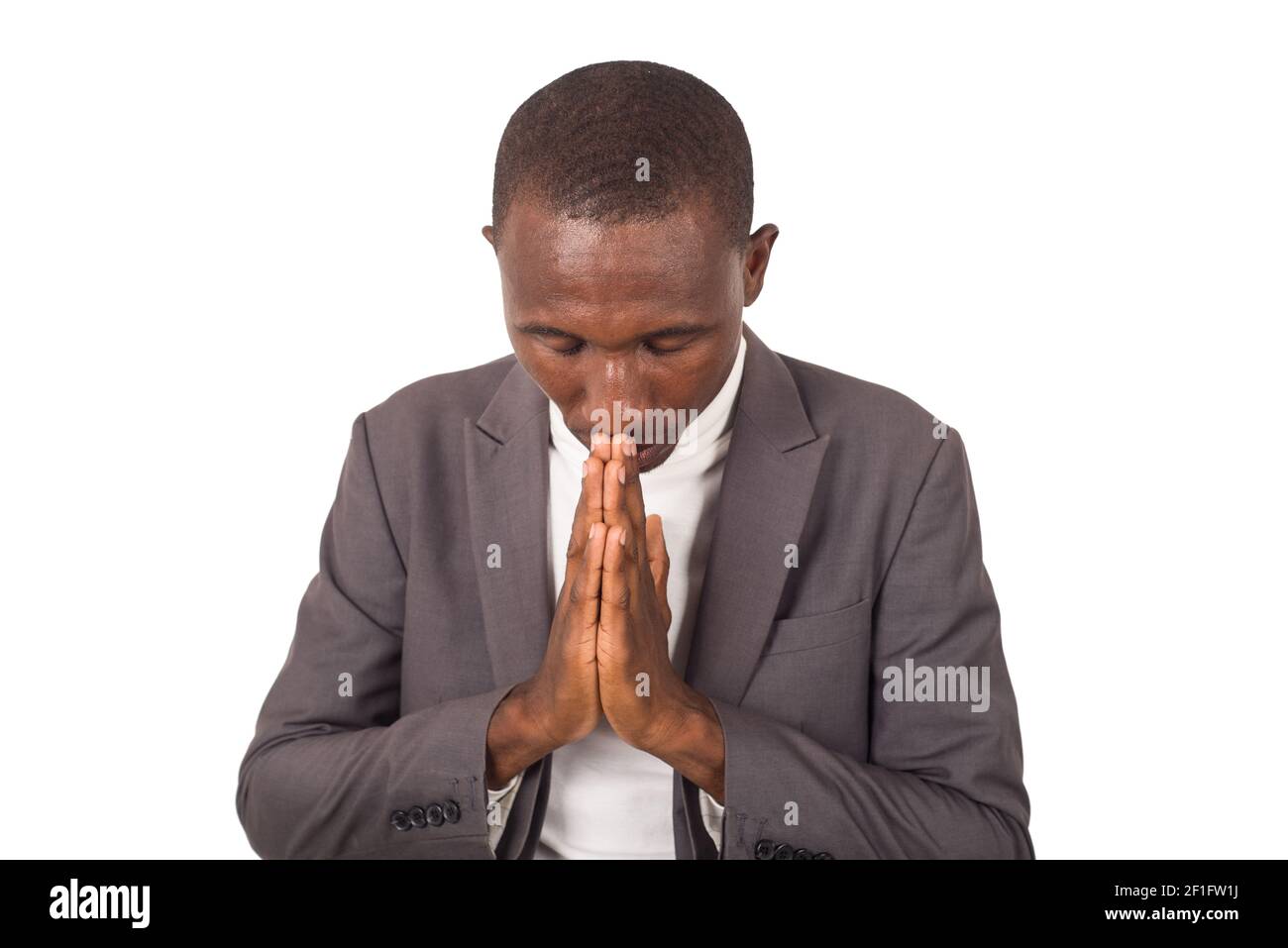 young man standing in suit on white background praying Stock Photo - Alamy
