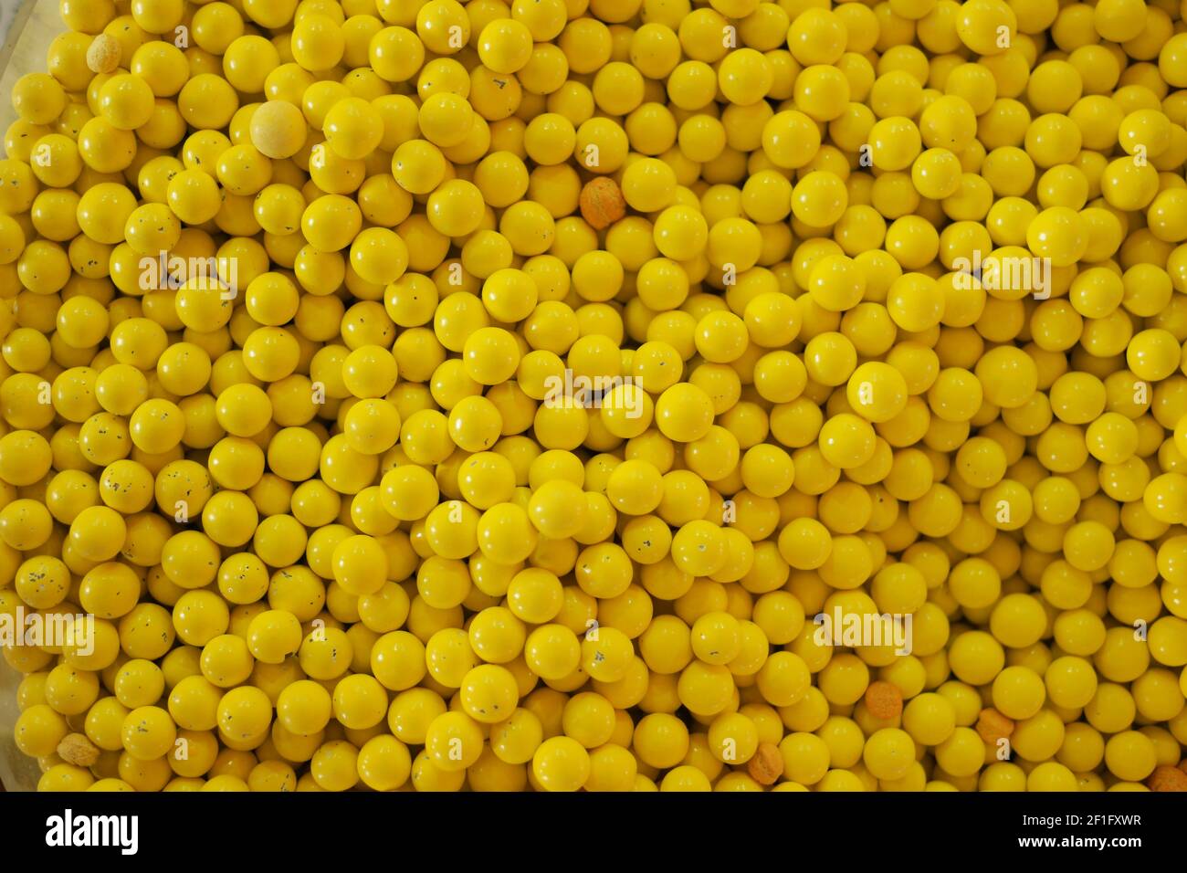 Small round yellow candies background Stock Photo - Alamy
