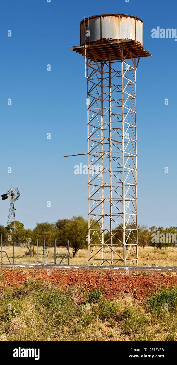 In the outback with asphalt line and water tank Stock Photo - Alamy