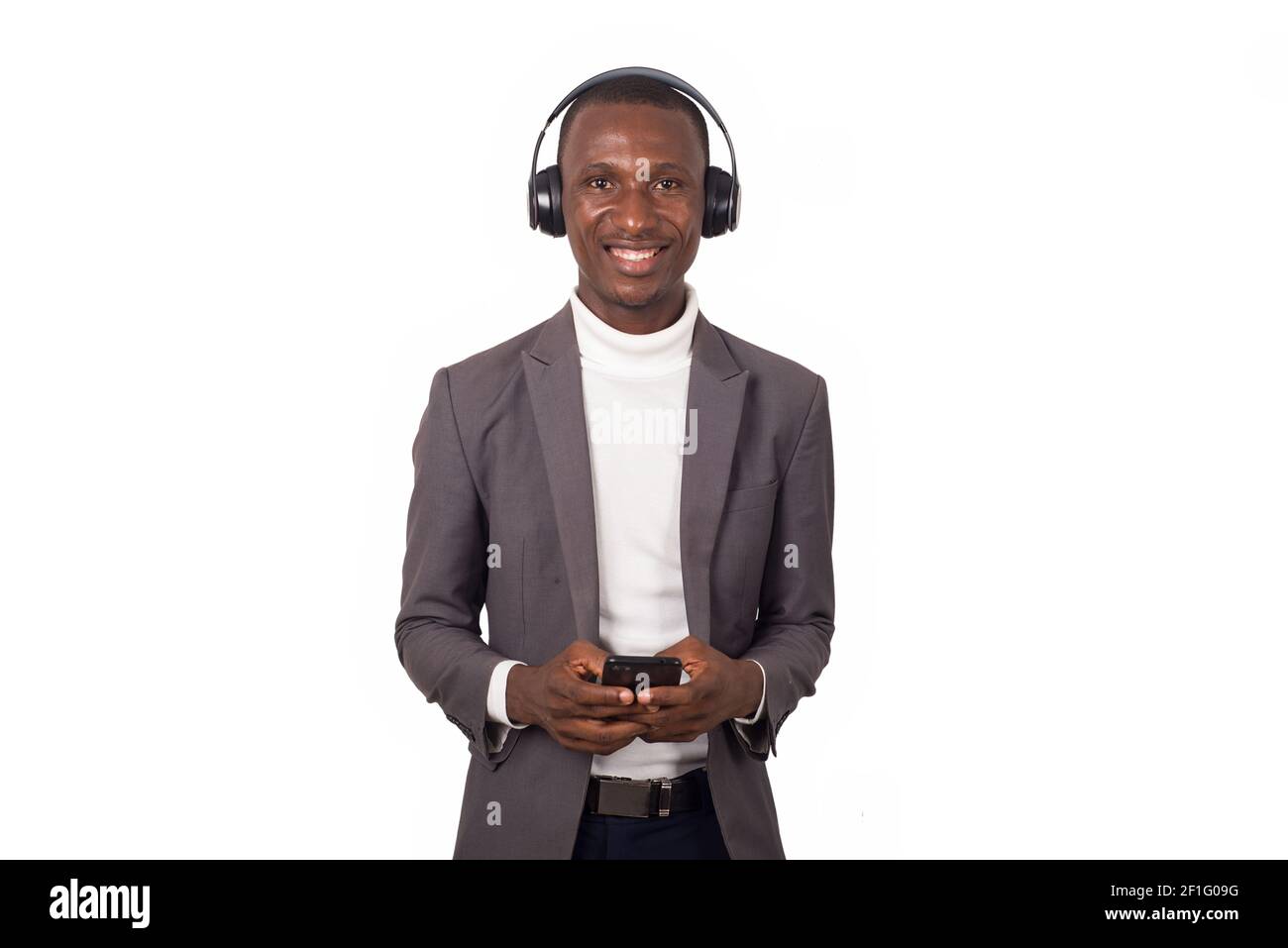 Happy young man in suit with headphones listening to music isolated on ...