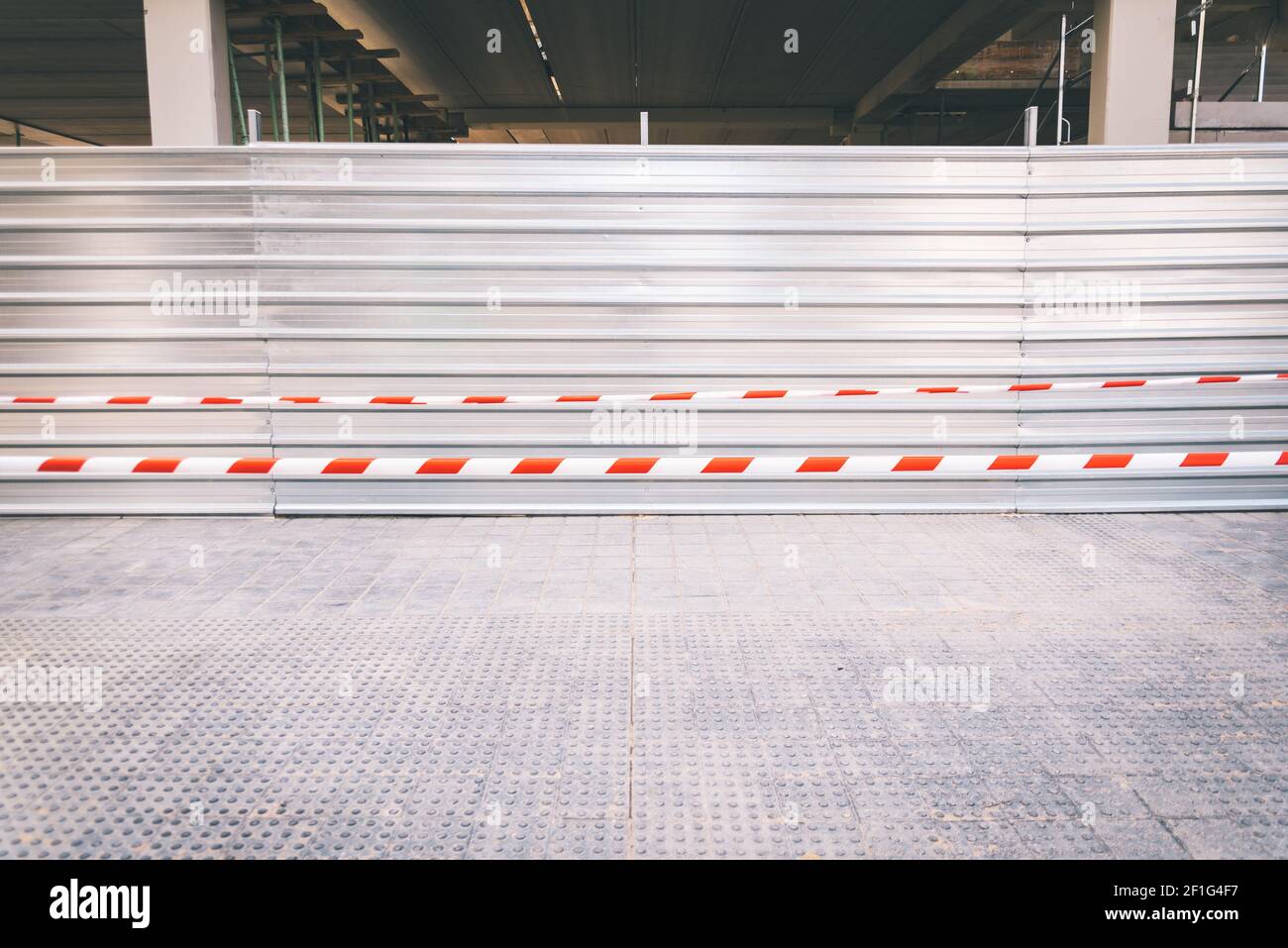 White and red plastic security tapes prevent access to a construction ...