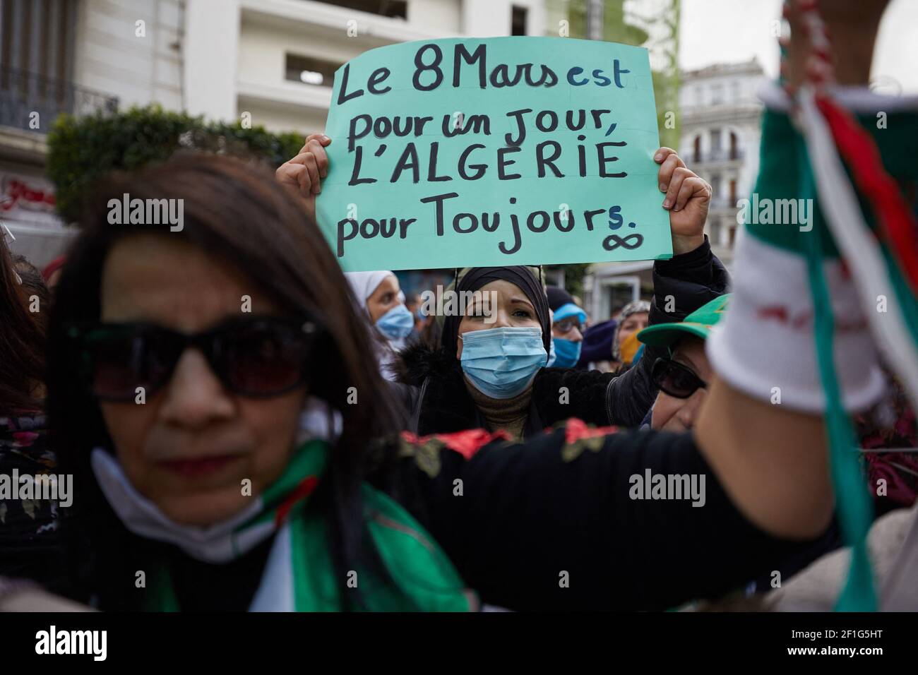 Protesters carry banners as they march during a protest marking ...