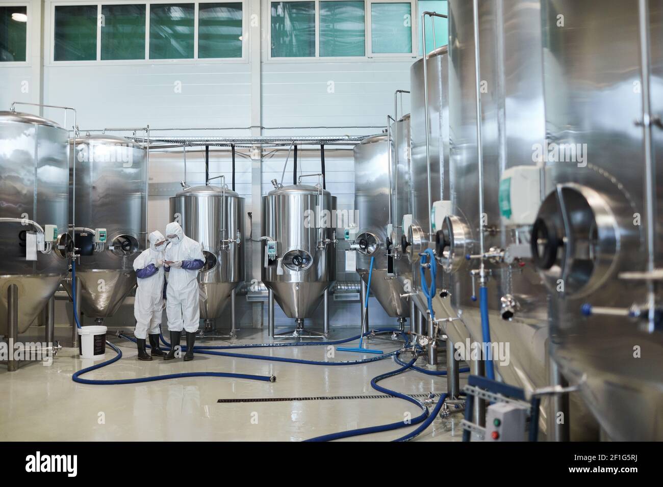 Wide angle background with two workers wearing protective suits at ...