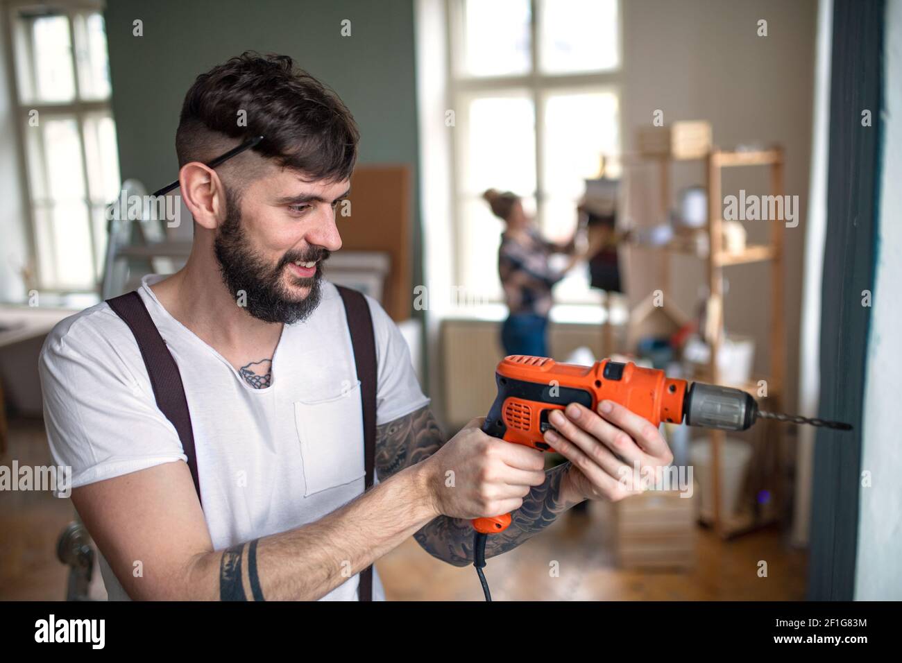 Man with drill working indoors at home, relocation and diy concept ...