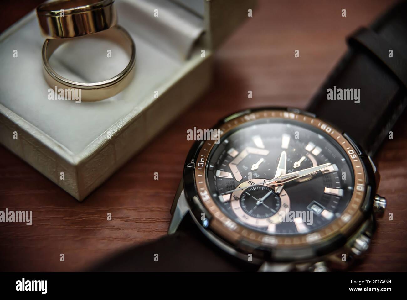 Wedding ring in a box and watch the groom Stock Photo - Alamy